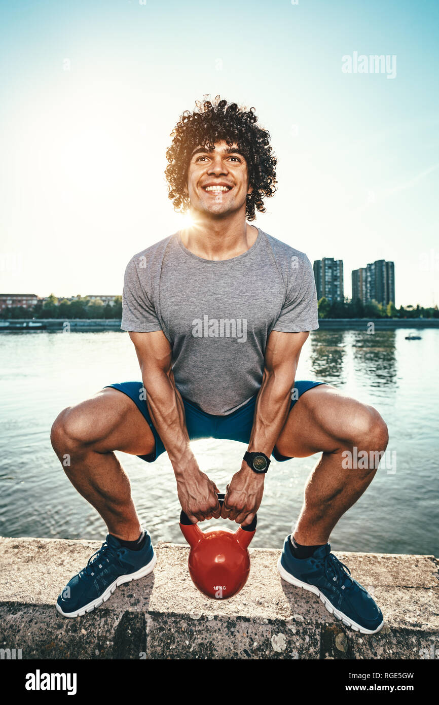 Bodybuilder is crouching and doing strong fit body training with ...