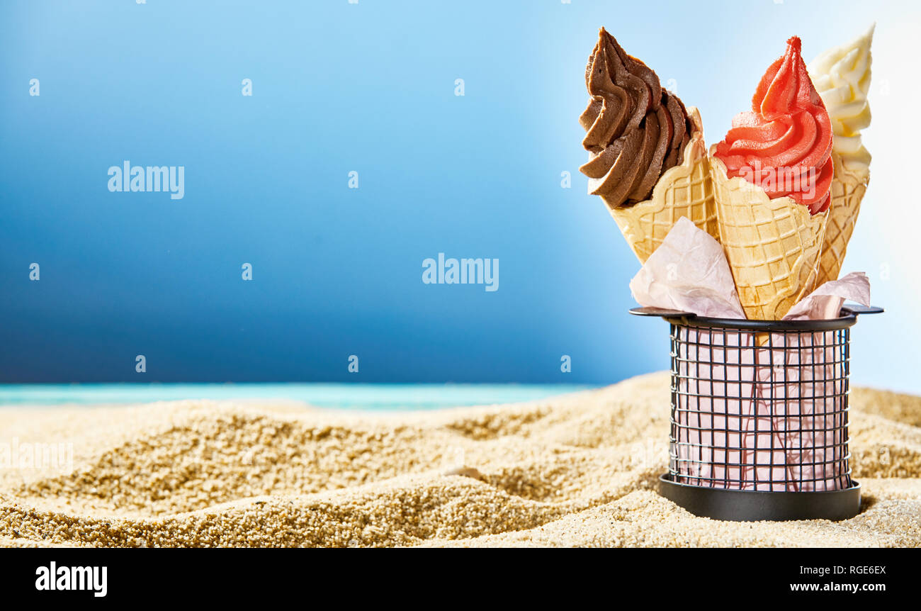 Colourful ice cream in crispy cones stuck into container on beach Stock ...