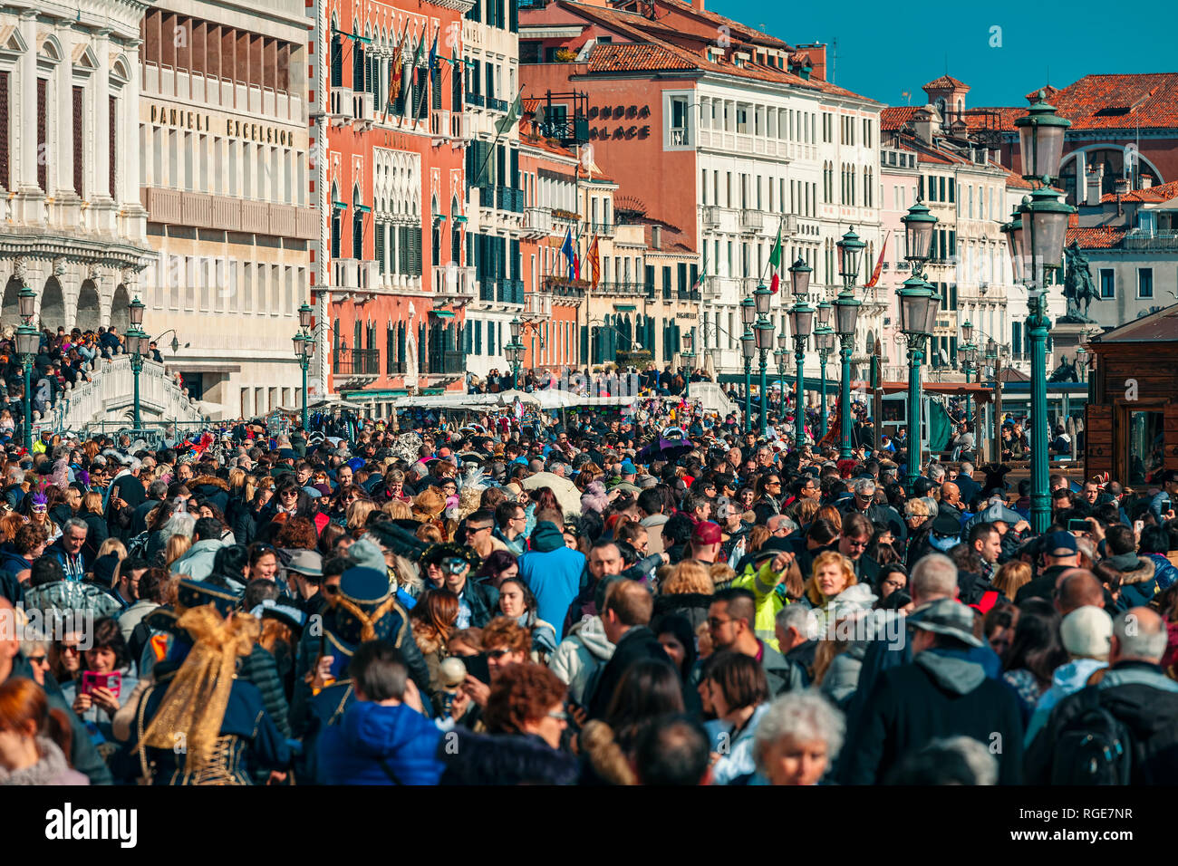 Crowds of tourists walking by typical venetian buildings near San Marco ...