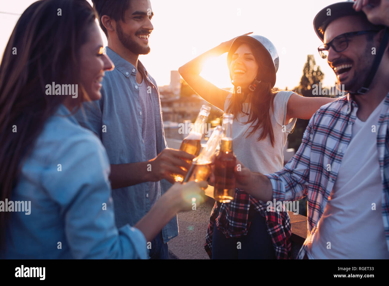 Young friends hanging out with drinks on rooftop Stock Photo - Alamy