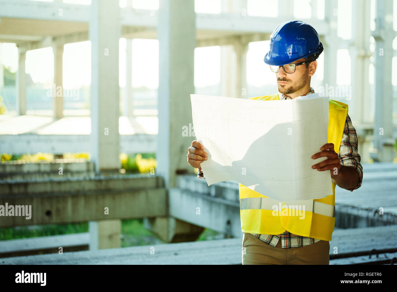 Picture of construction site engineer looking at plan Stock Photo - Alamy