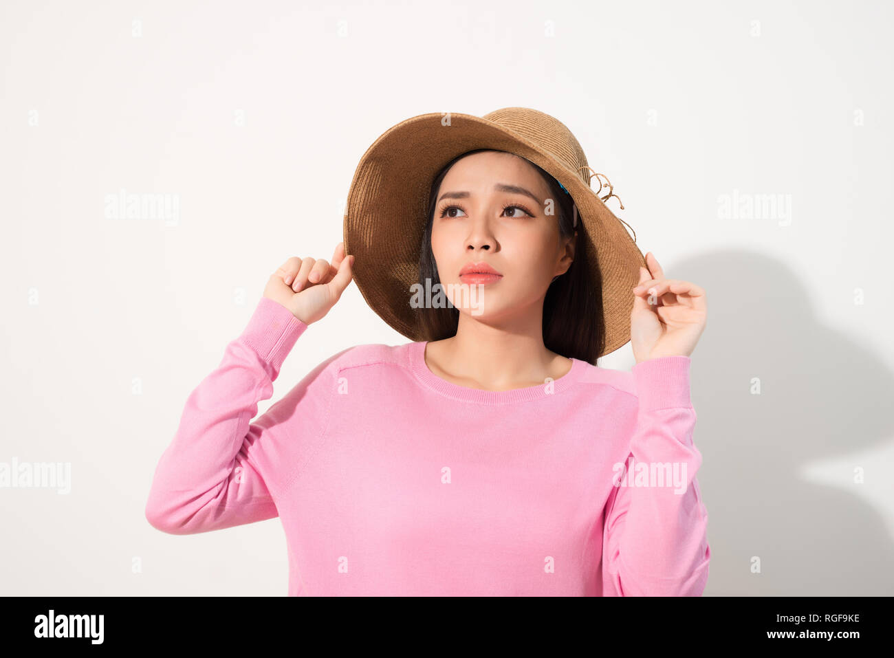 Closeup of sad pensive young woman and straw hat thinking and feeling ...