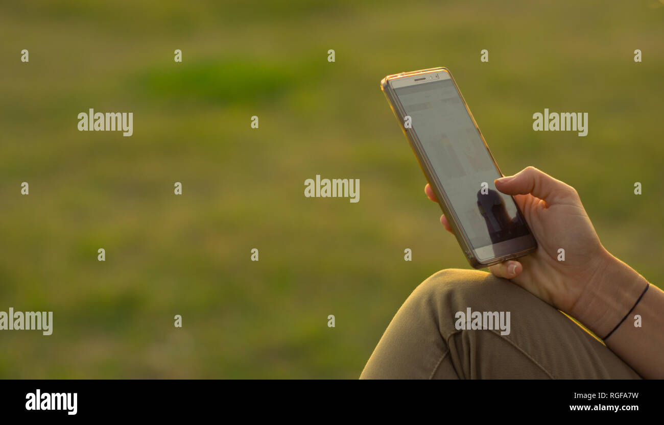Hand holding cell phone. About being outside and being connected. No ...
