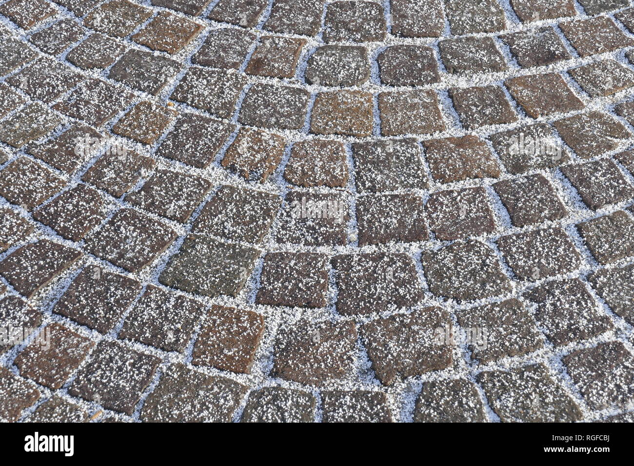 Cobblestone covered with snow grains Stock Photo - Alamy