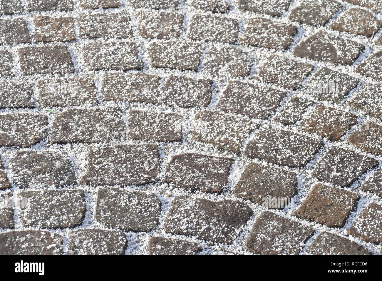 Cobblestone covered with snow grains Stock Photo - Alamy