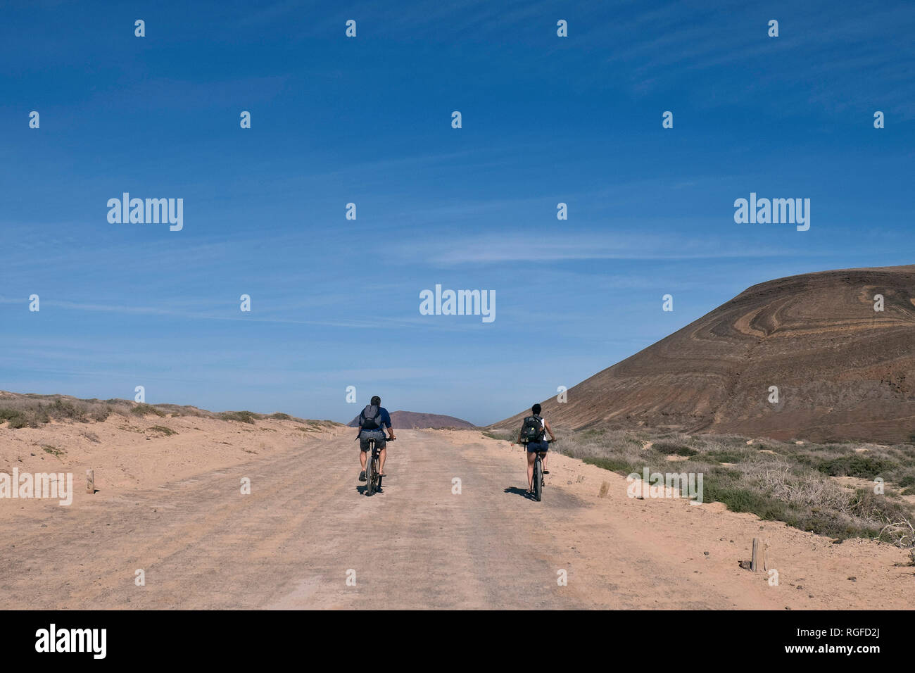 Cyclist on an unpaved track of the smallest Canary Island La Graciosa ...
