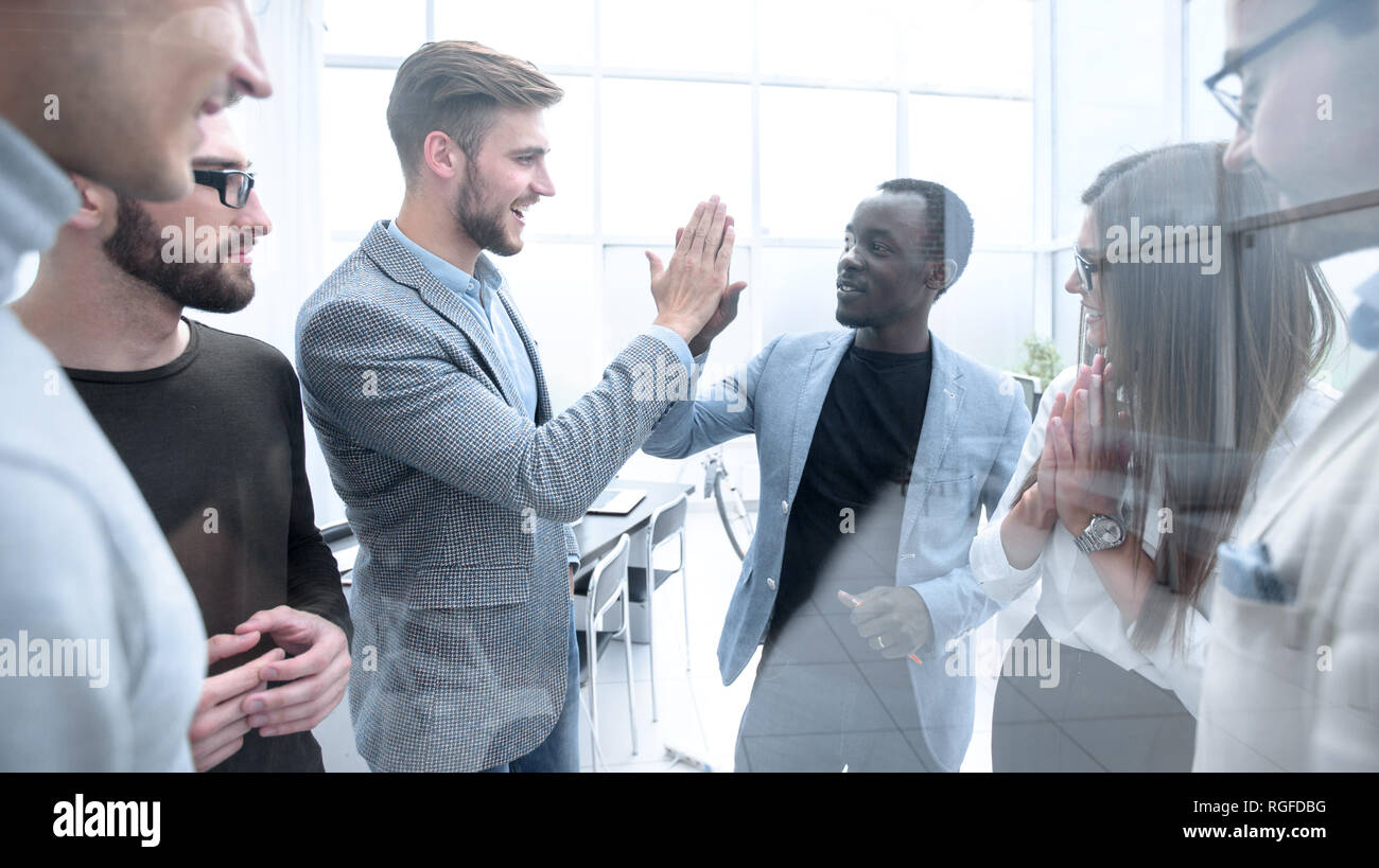 happy colleagues giving each other a high five Stock Photo - Alamy