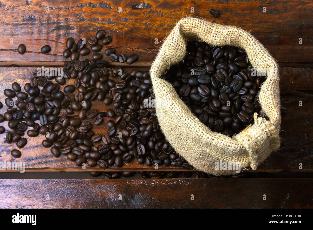 roasted and fresh coffee beans inside rustic fabric bag and poured over ...