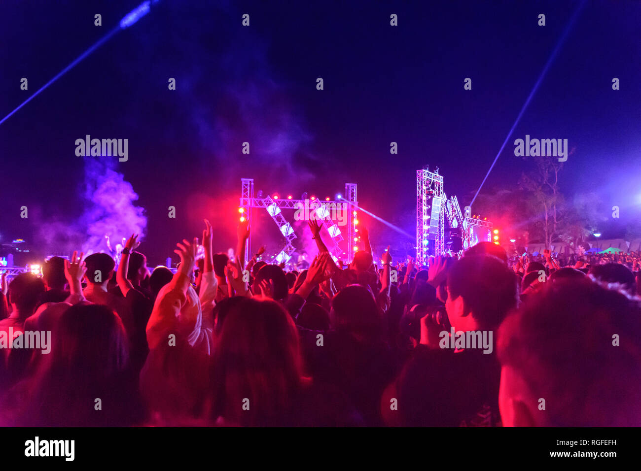Concert crowd attending a mini concert, people are visible, backlit by ...