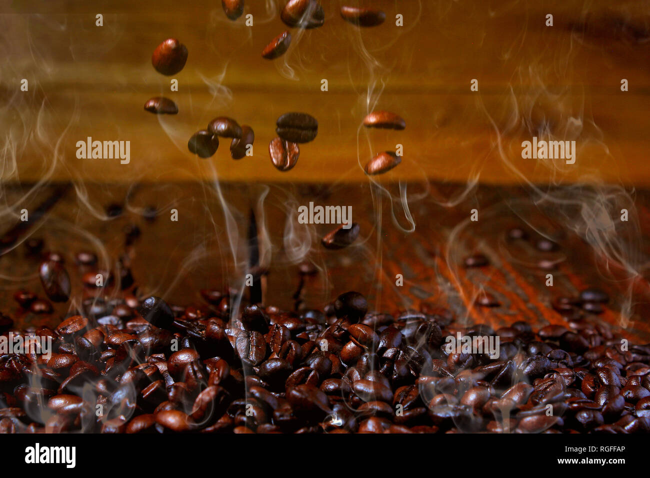 roasted coffee beans falling on stack, hot and smoky. close-up view ...