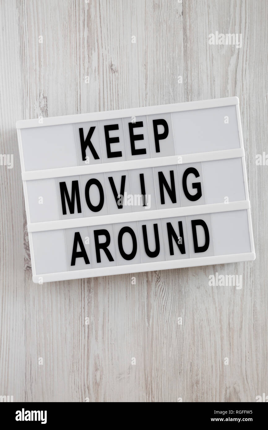 'Keep moving around' words on modern board over white wooden background ...