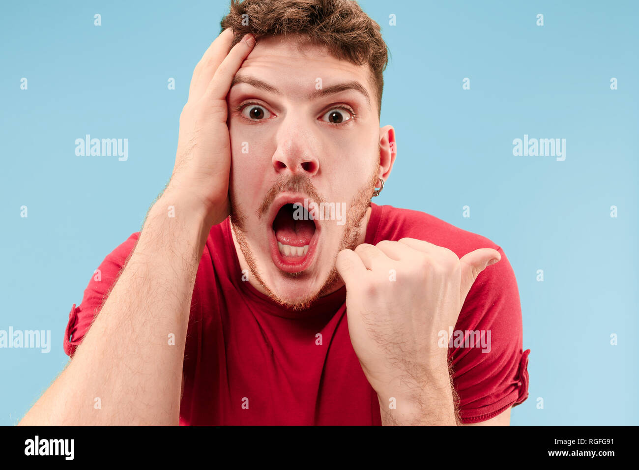 Wow. Attractive male half-length front portrait on blue studio ...