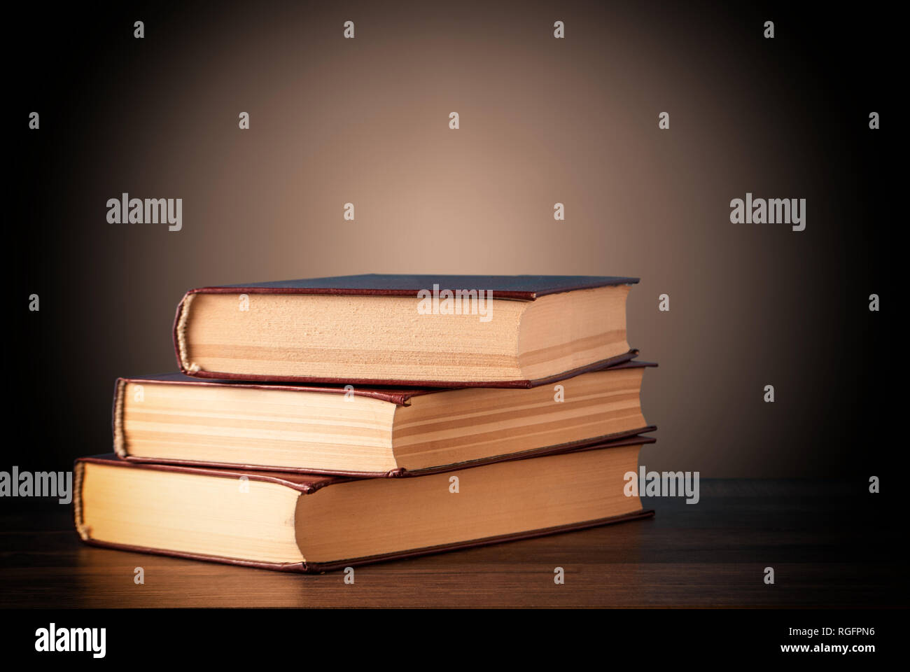books on a blurred brown background and a bright circle in the center ...