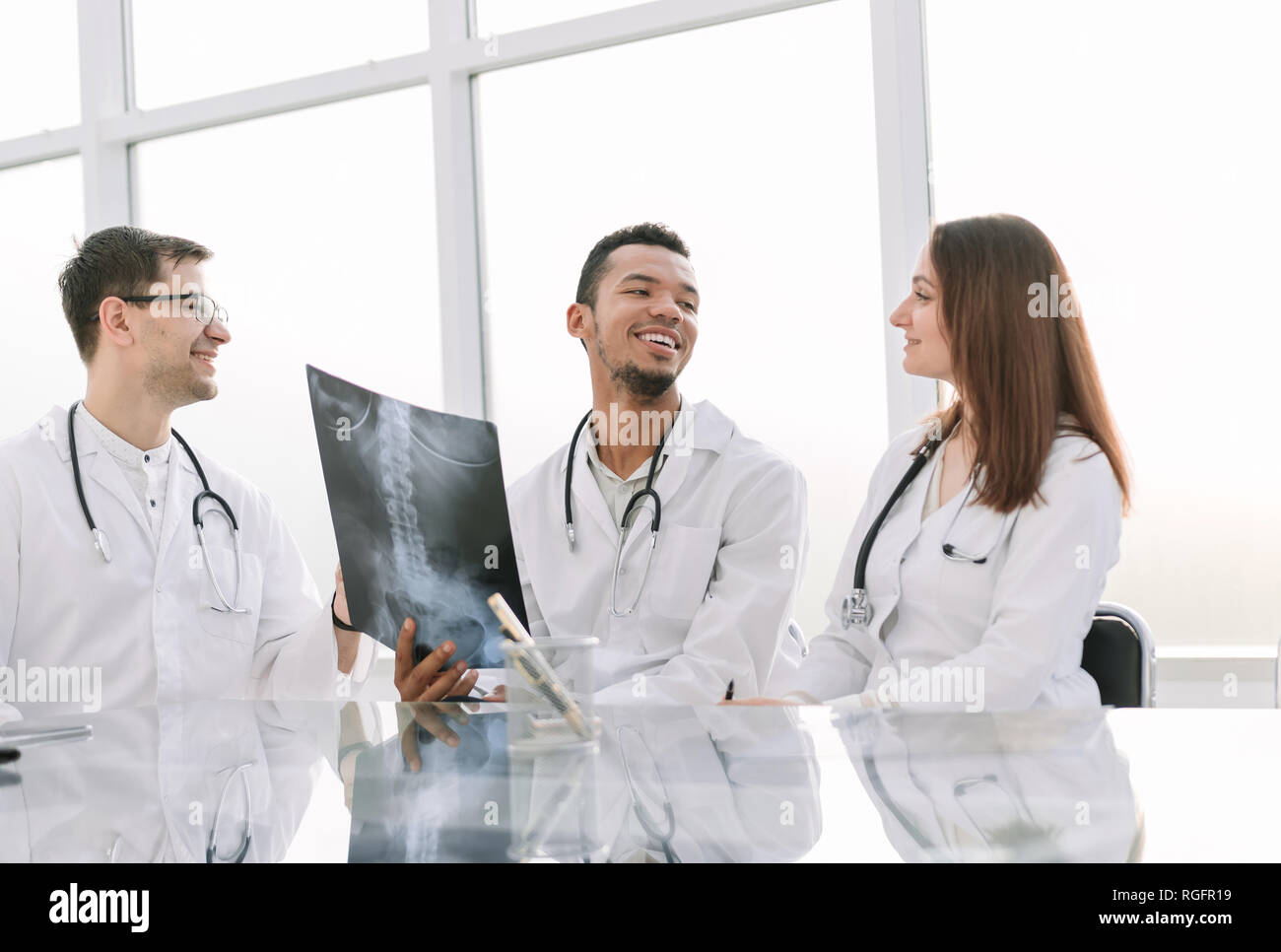 medical colleagues discuss x-ray, sitting at the office table Stock ...