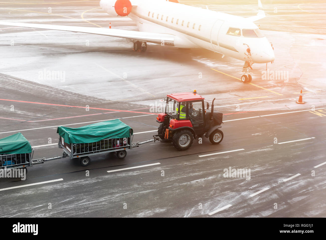 cargo freight tractor machine delivering luggage carts to airplane at ...
