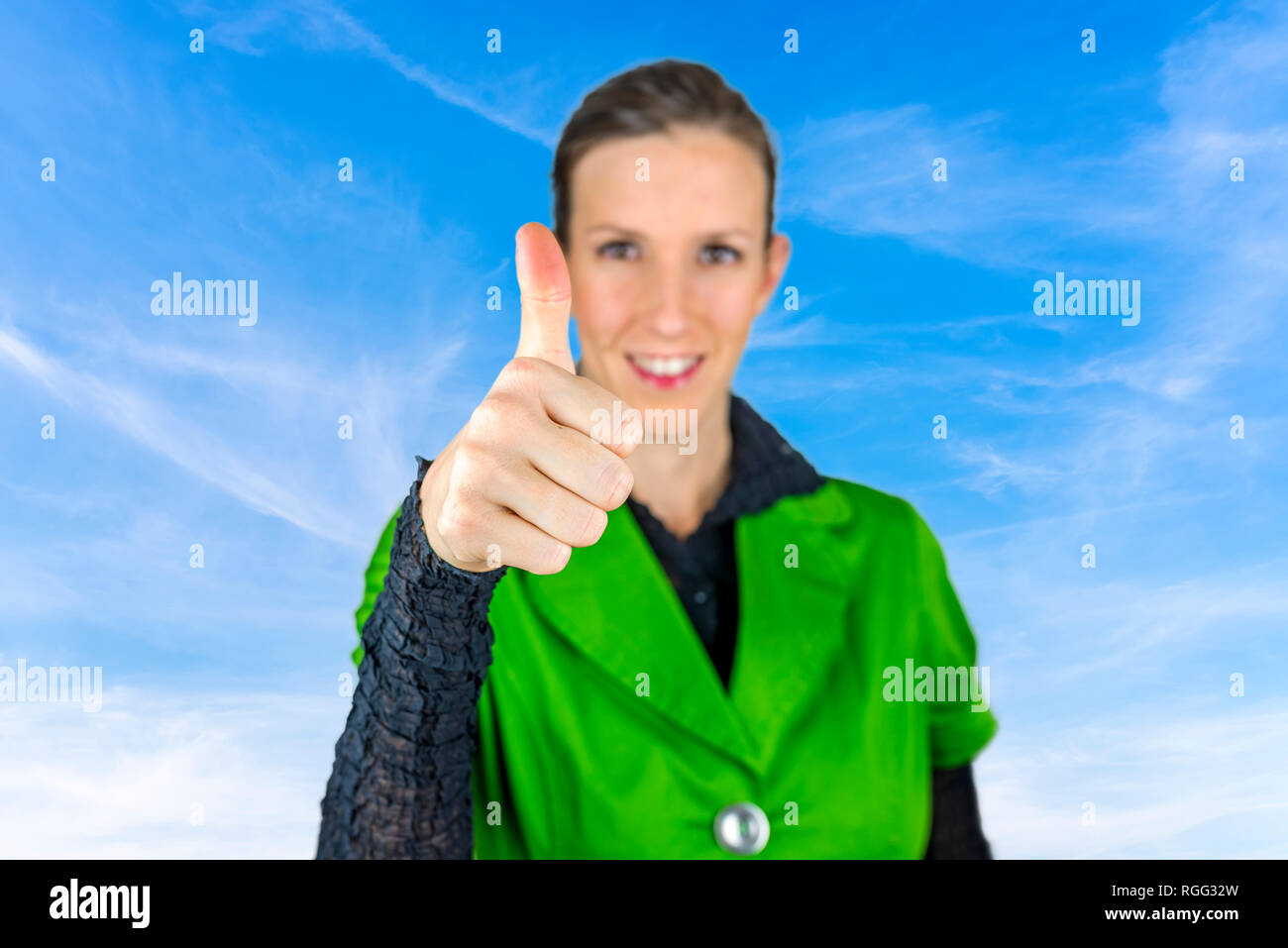 Business woman making thumbs up sign over blue sky Stock Photo - Alamy