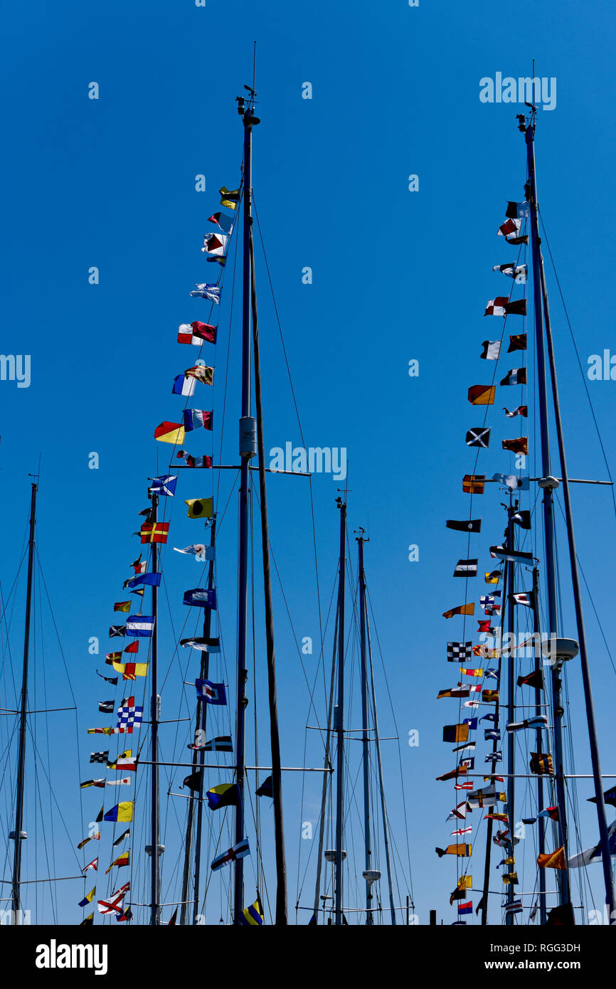 Yacht masts with signal flags dressed overall against a blue sky Stock ...