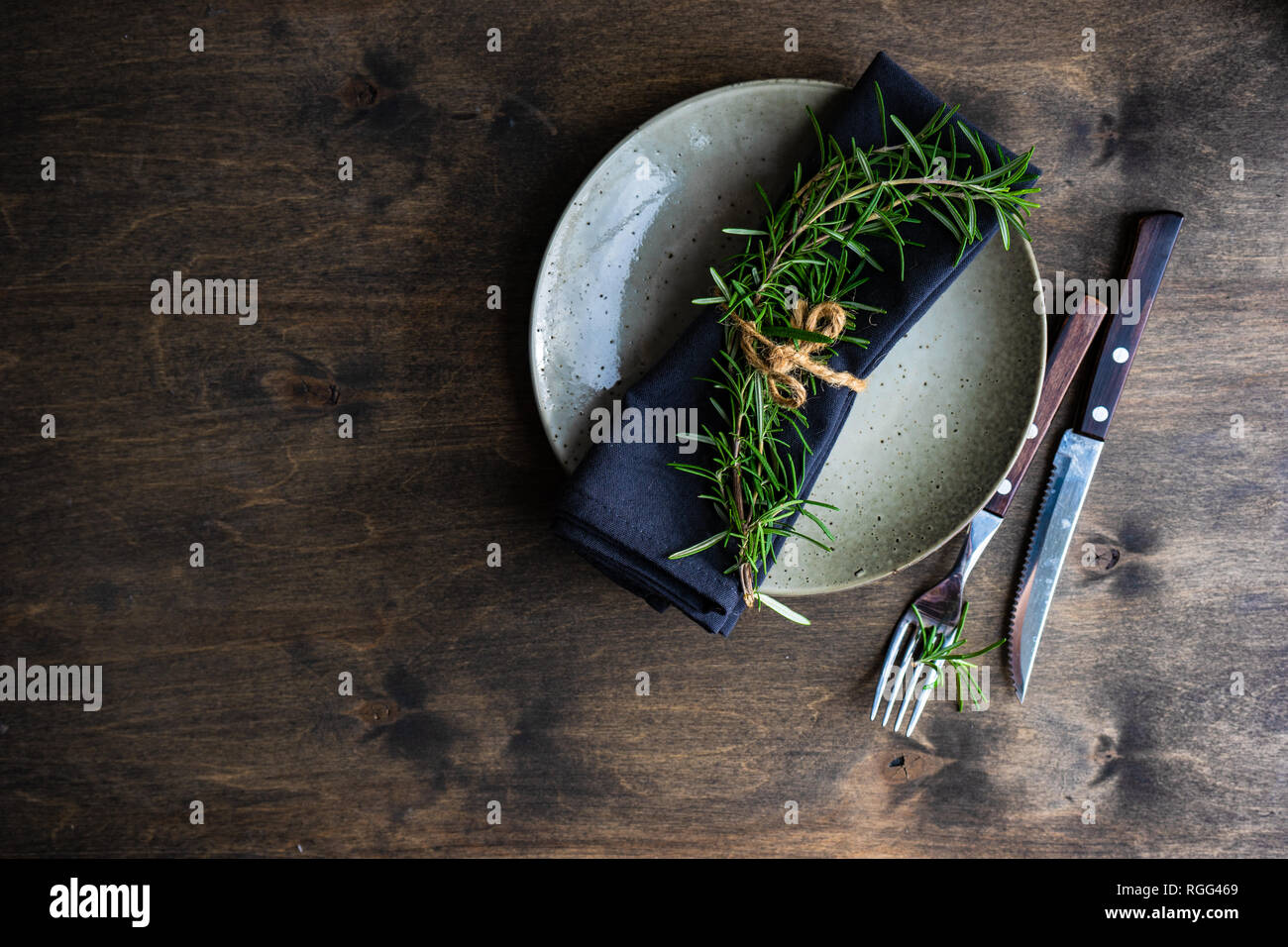Table setting with rosemary herb on vintage wooden table with copy ...