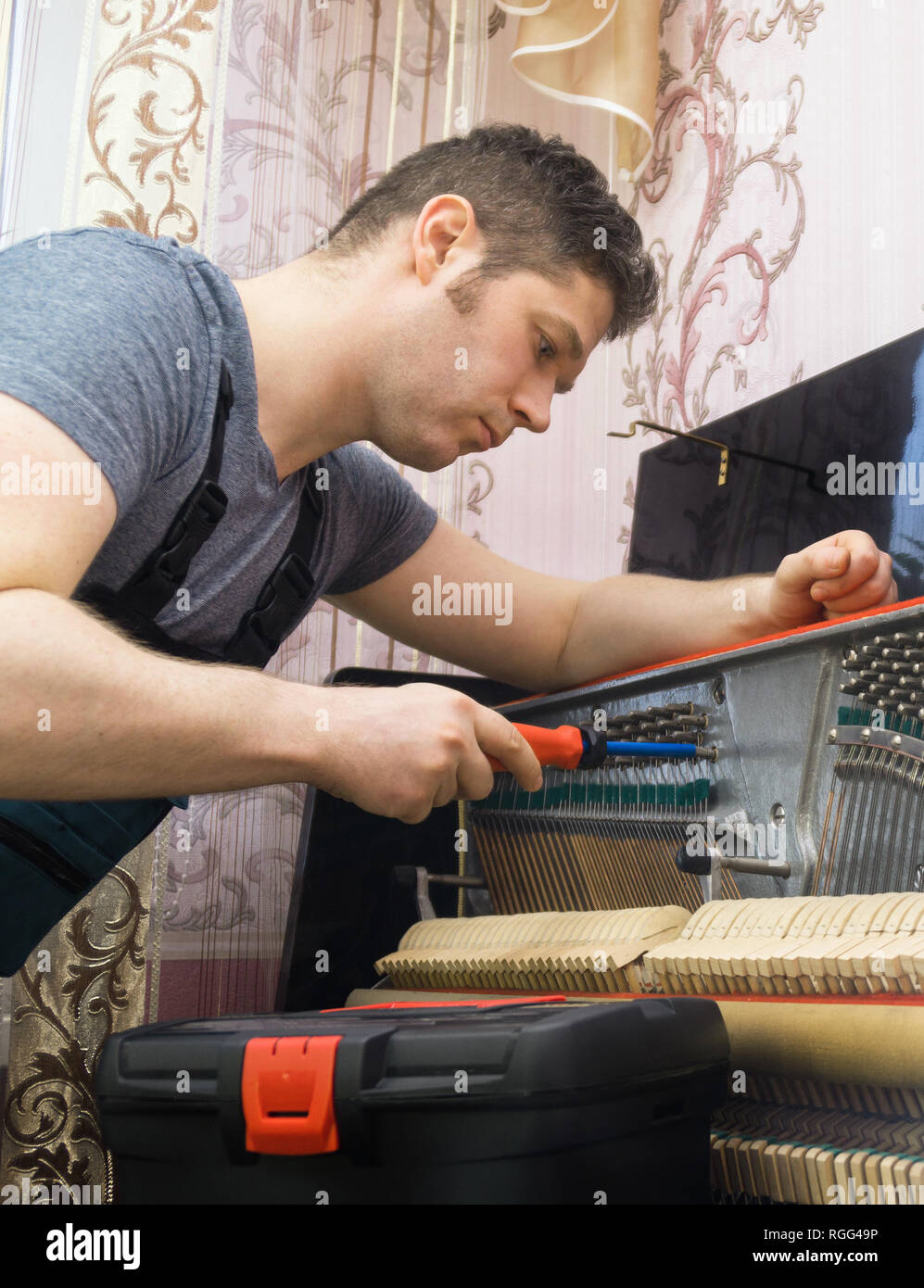 Professional master tuning the piano with ratchet tool Stock Photo - Alamy