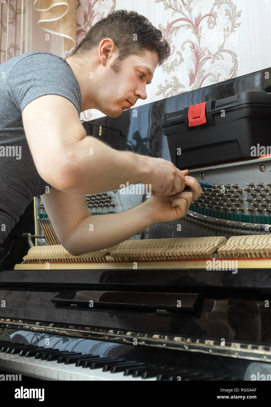 Professional master tuning the piano with ratchet tool Stock Photo - Alamy
