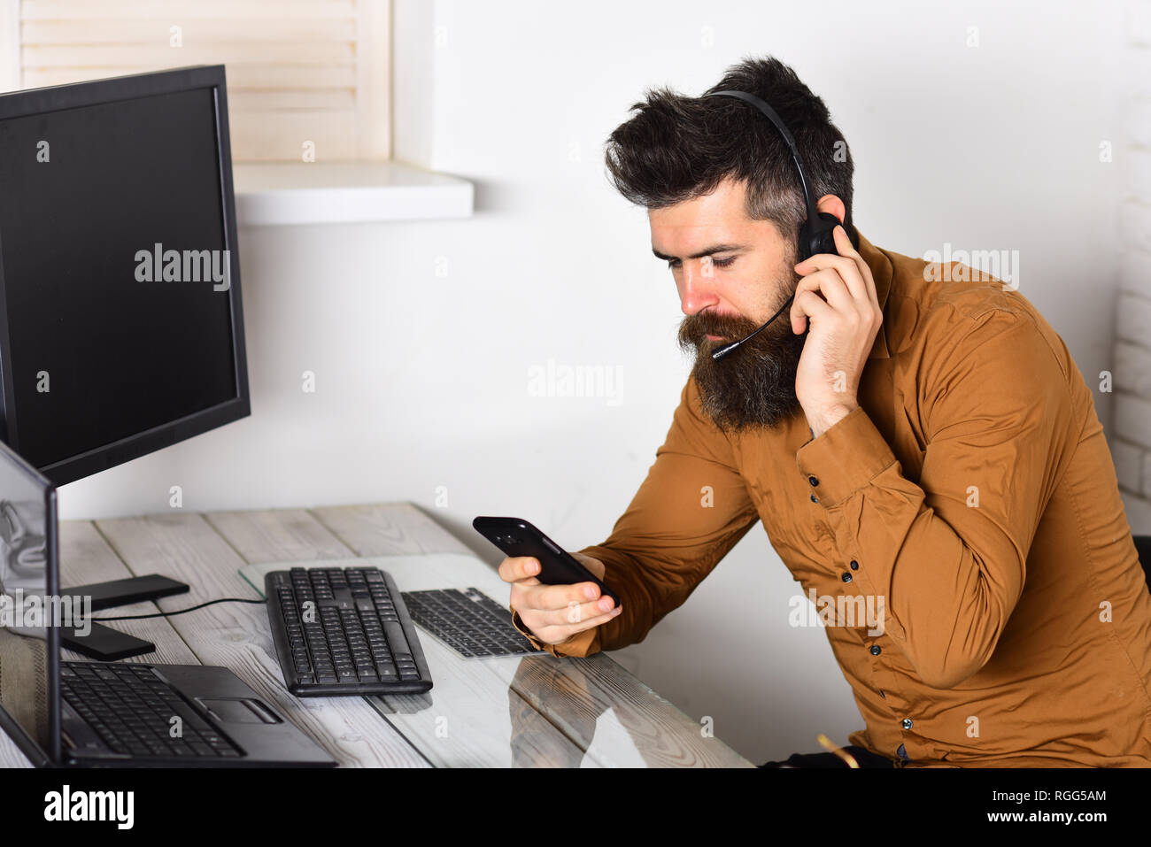 Ready to help. Call center operator at work. Bearded man working in ...