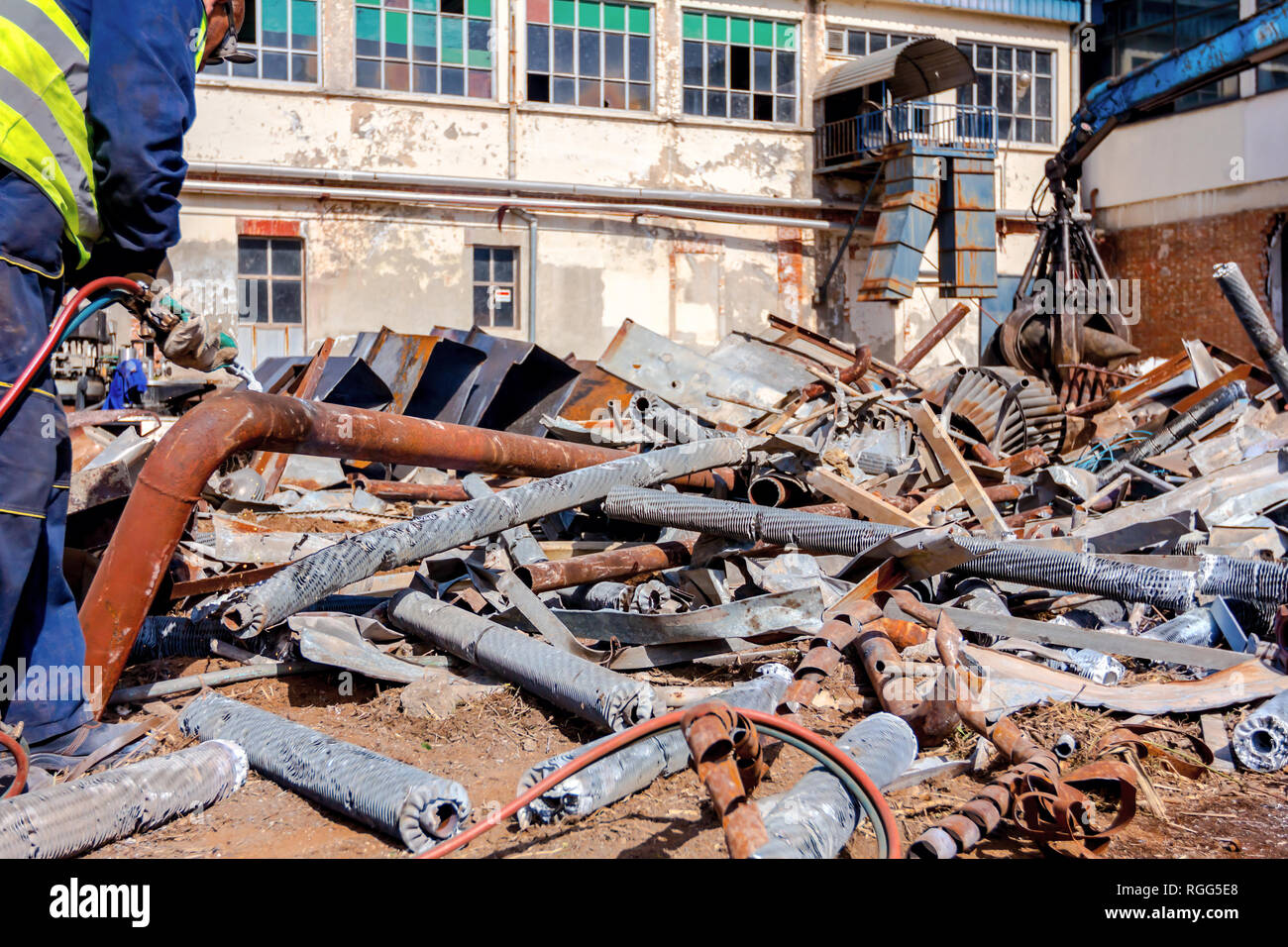 Worker is cutting waste metal with gas by mixing oxygen and acetylene ...