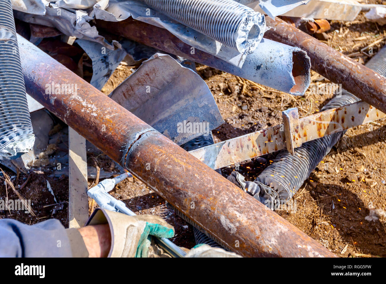 Worker is cutting waste metal with gas by mixing oxygen and acetylene ...