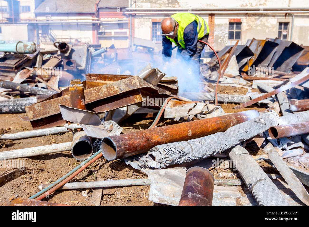 Worker is cutting waste metal with gas by mixing oxygen and acetylene ...