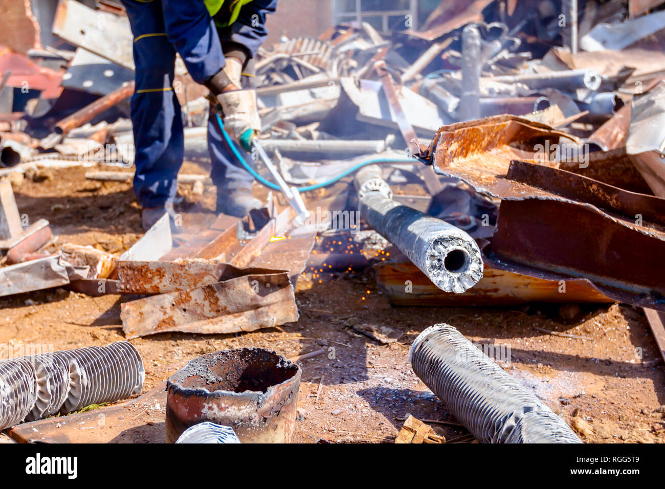 Worker is cutting waste metal with gas by mixing oxygen and acetylene ...
