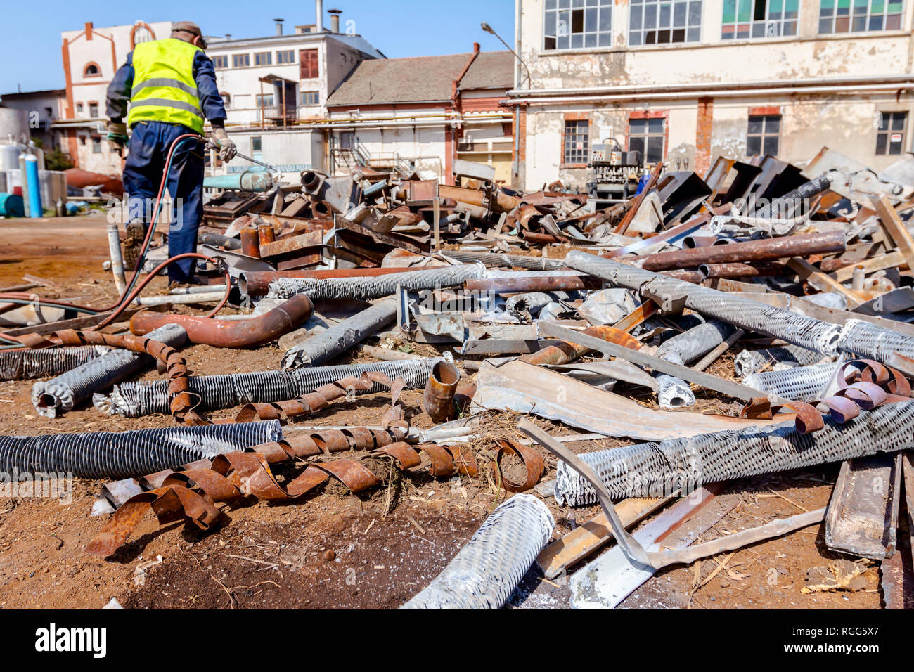 Worker is cutting waste metal with gas by mixing oxygen and acetylene ...