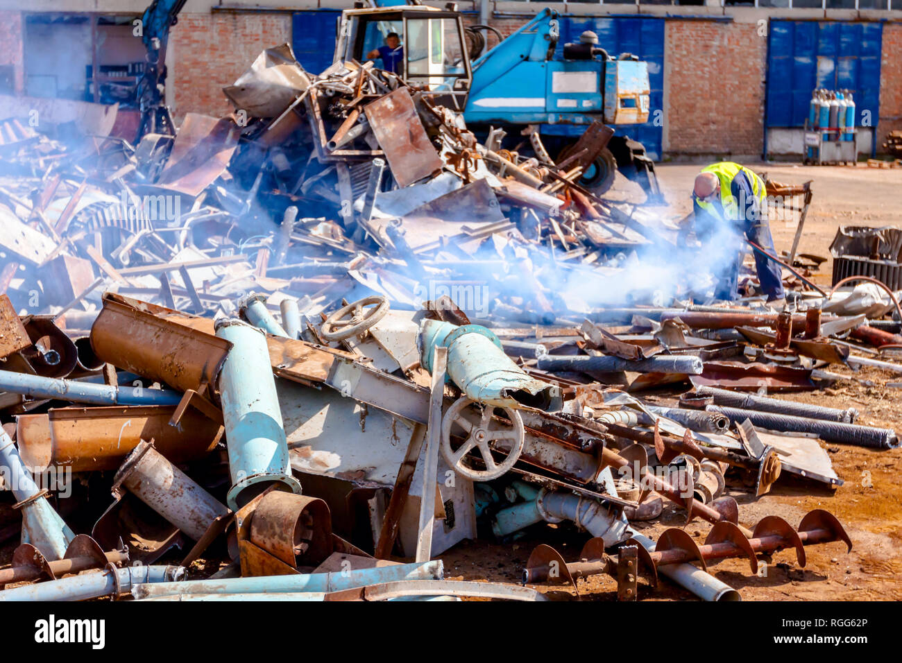 Worker is cutting waste metal with gas by mixing oxygen and acetylene ...