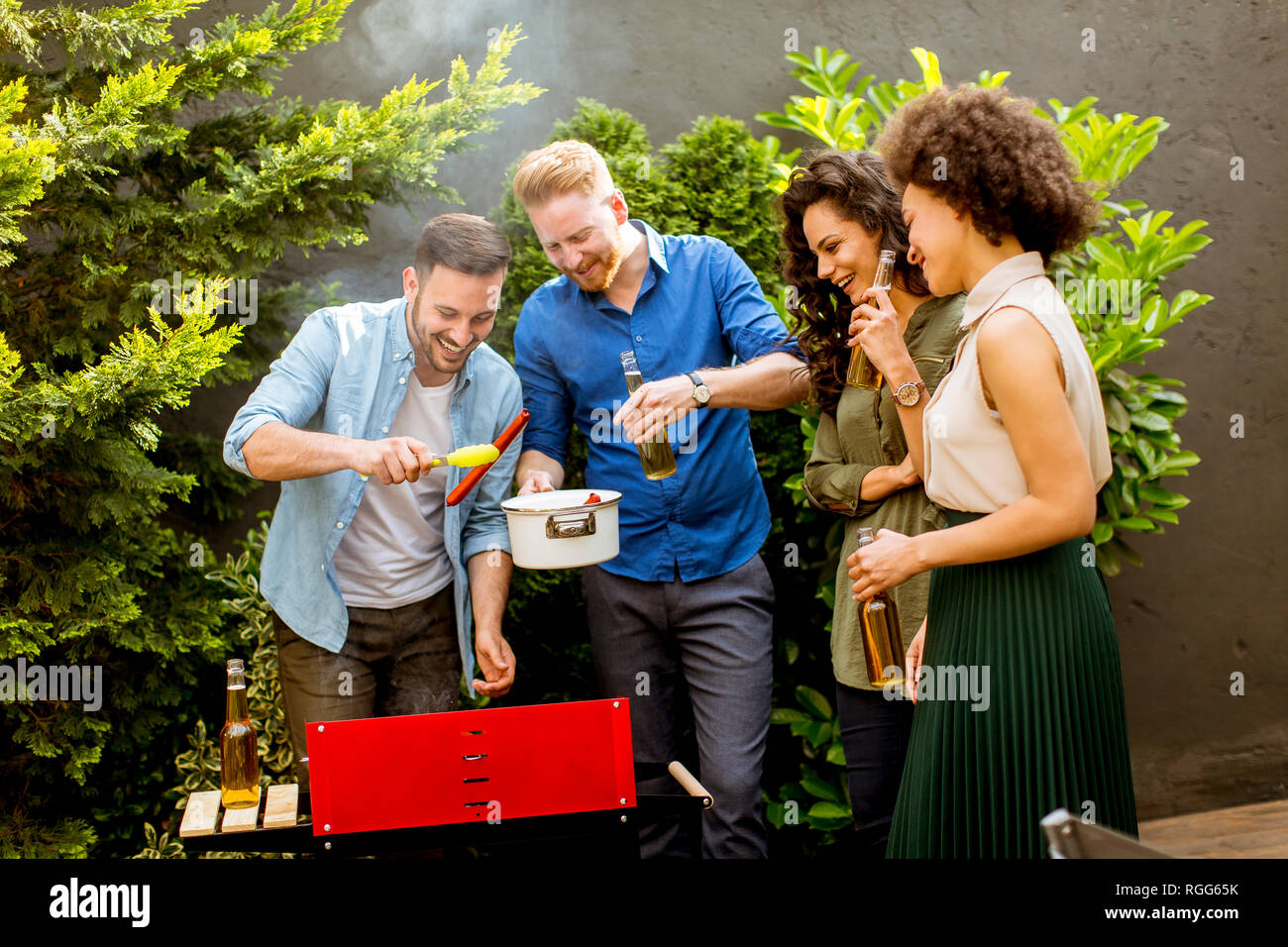 View at happy friends grilling food and enjoying barbecue party ...