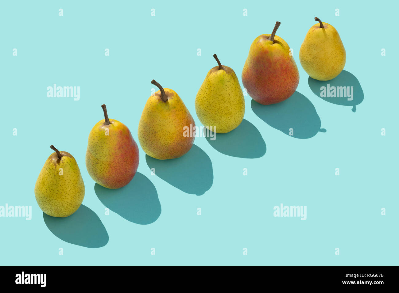 Multiple pears organized in a row over blue background Stock Photo - Alamy