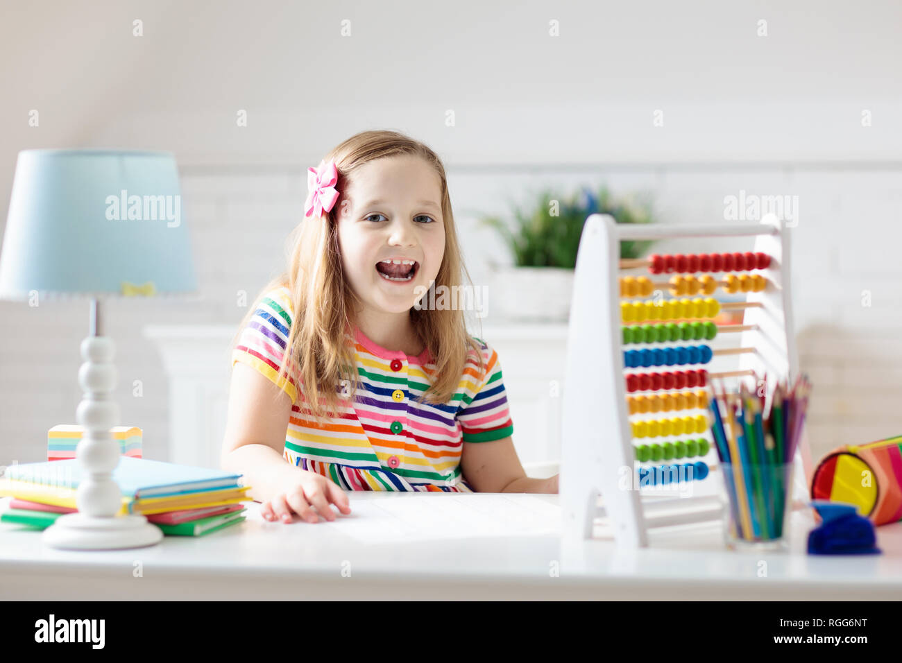 Child doing homework at home. Little girl with wooden colorful abacus ...