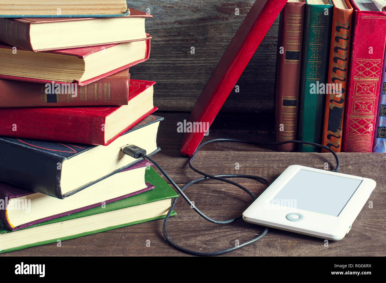 ebook and old books on wooden table. tablet download information from ...