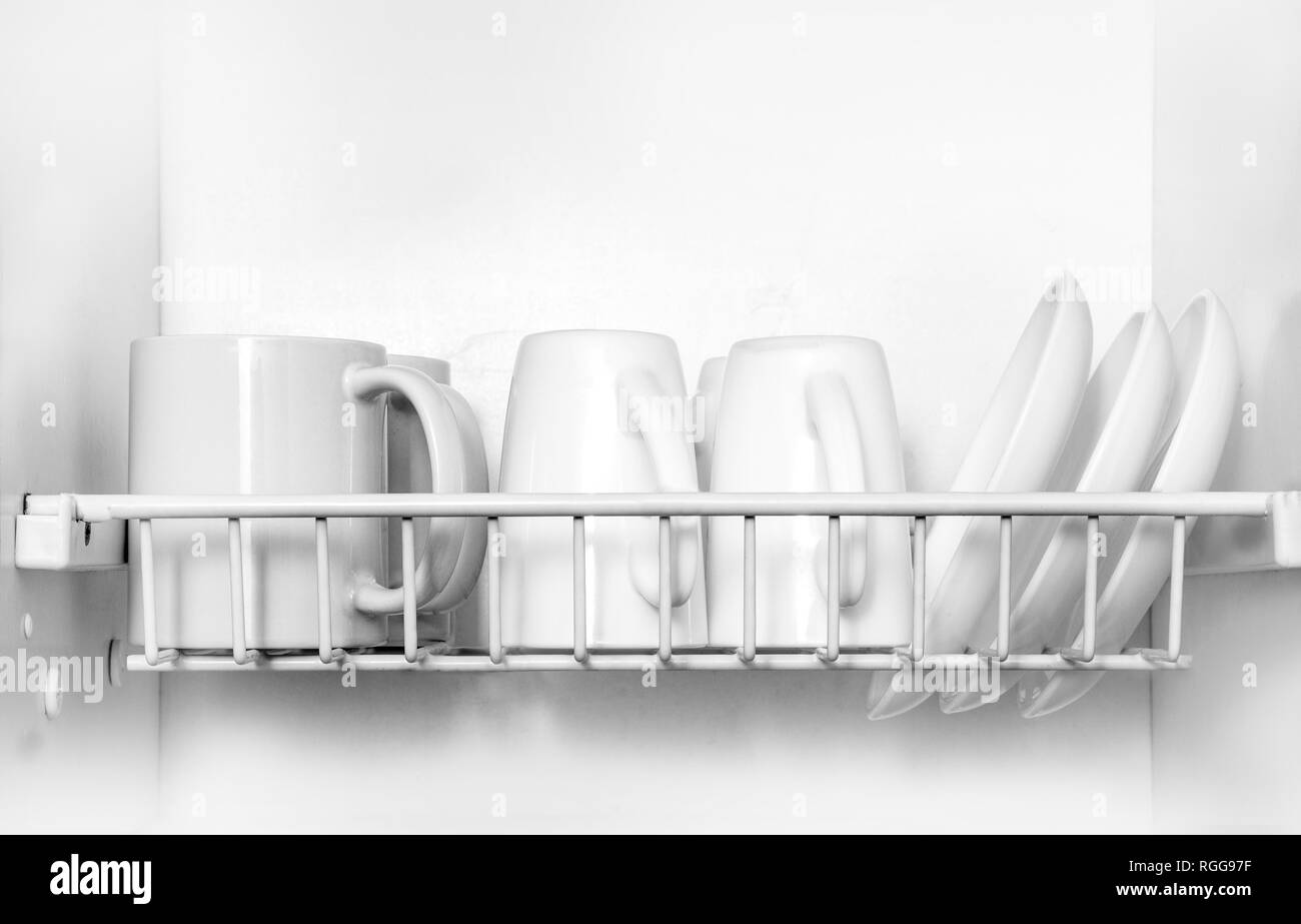 Clean dishes drying on metal dish rack on shelf Stock Photo - Alamy