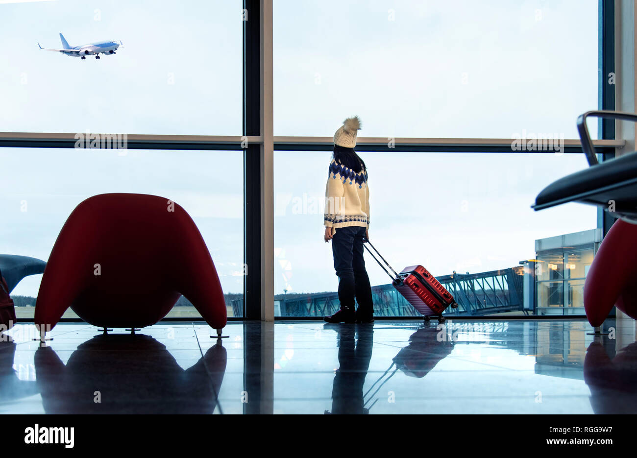 Girl waiting at the airport with suitcase Stock Photo - Alamy