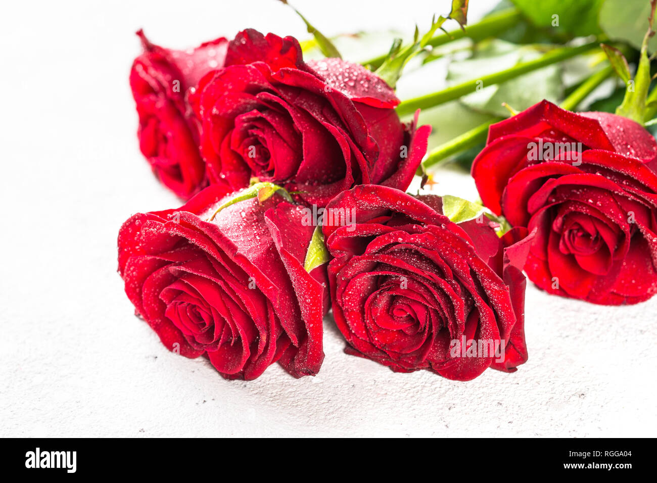Red roses flower bouquet on white stone table Stock Photo - Alamy