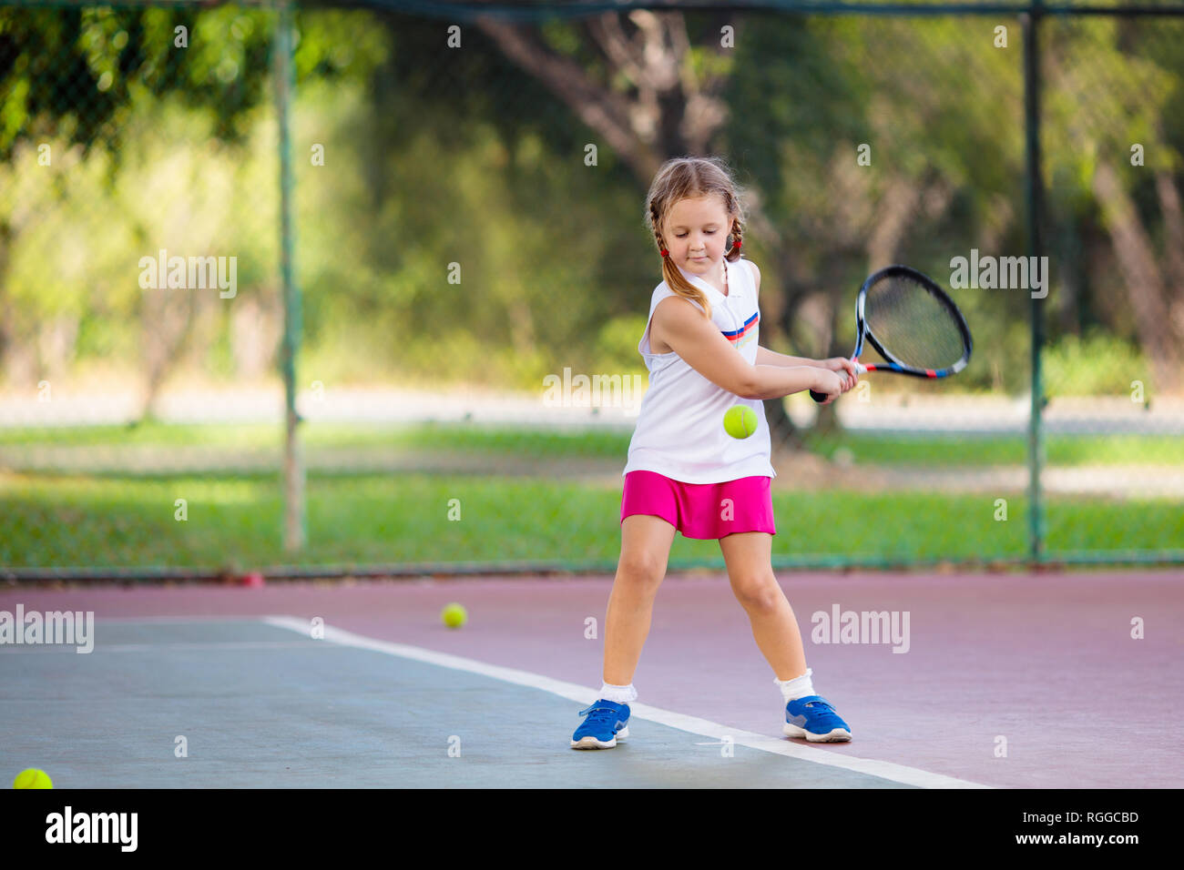 Child playing tennis on indoor court. Little girl with tennis racket ...