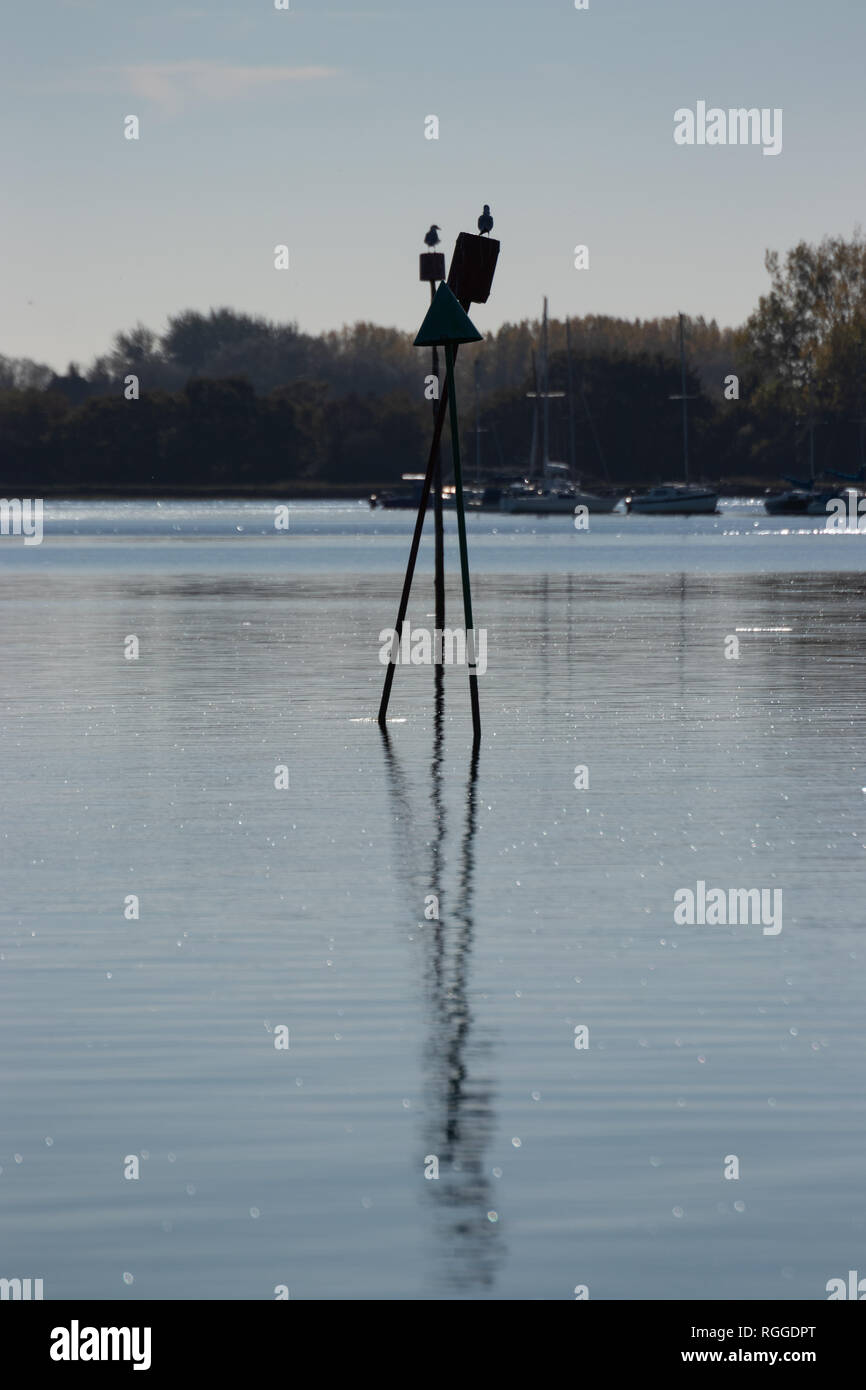 sea markers reflecting on calm blue water Stock Photo - Alamy