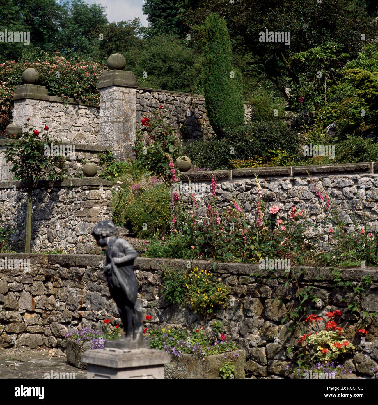Small statue in terraced garden with old stone walls Stock Photo - Alamy
