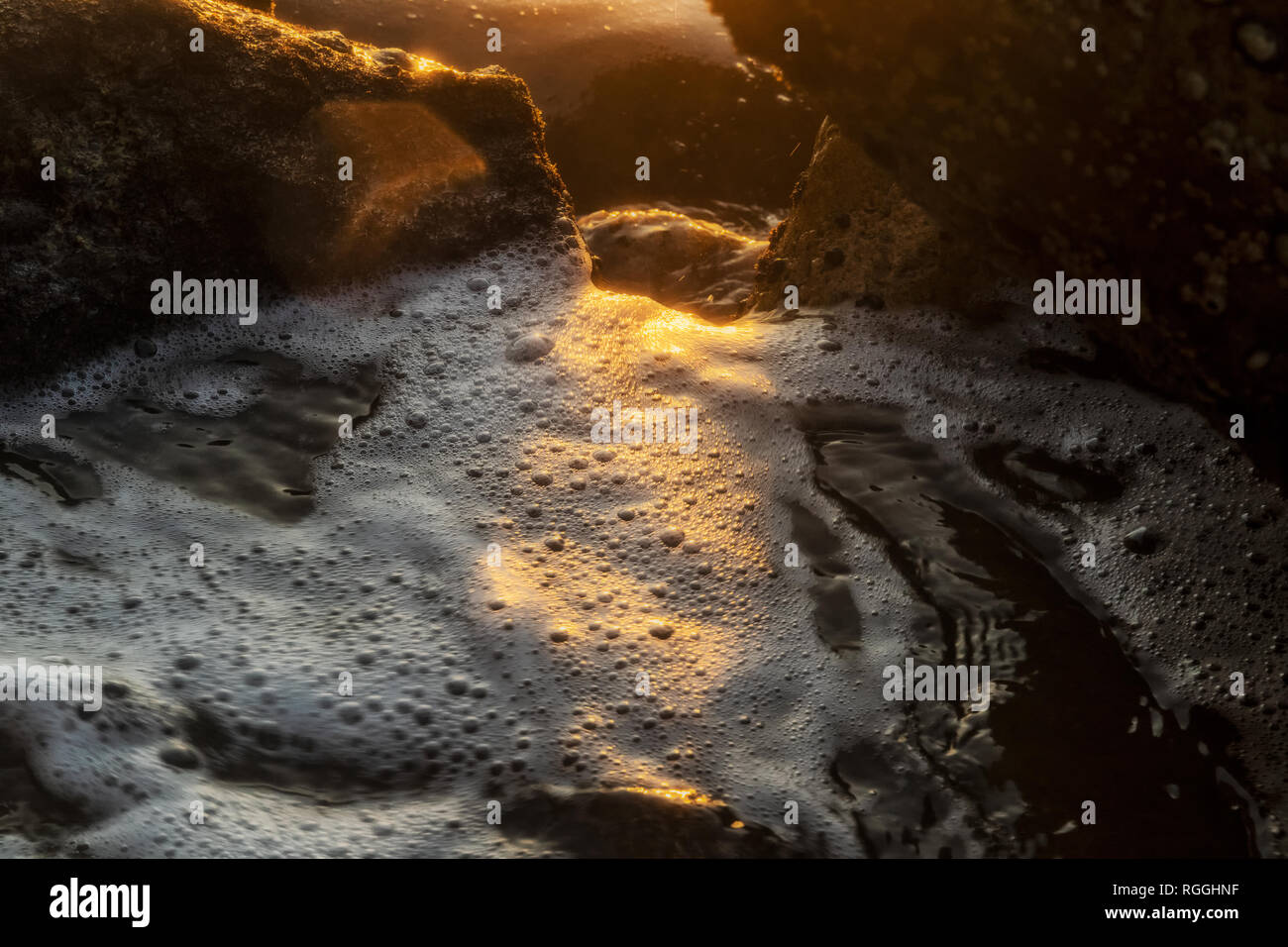Marine swimming pool formed by rocks on the beach with beautiful sunset ...