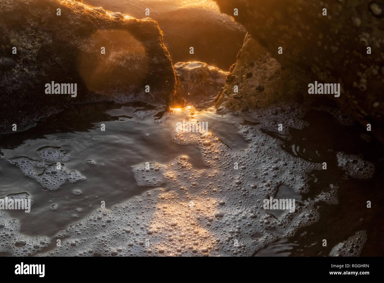 Marine swimming pool formed by rocks on the beach with beautiful sunset ...