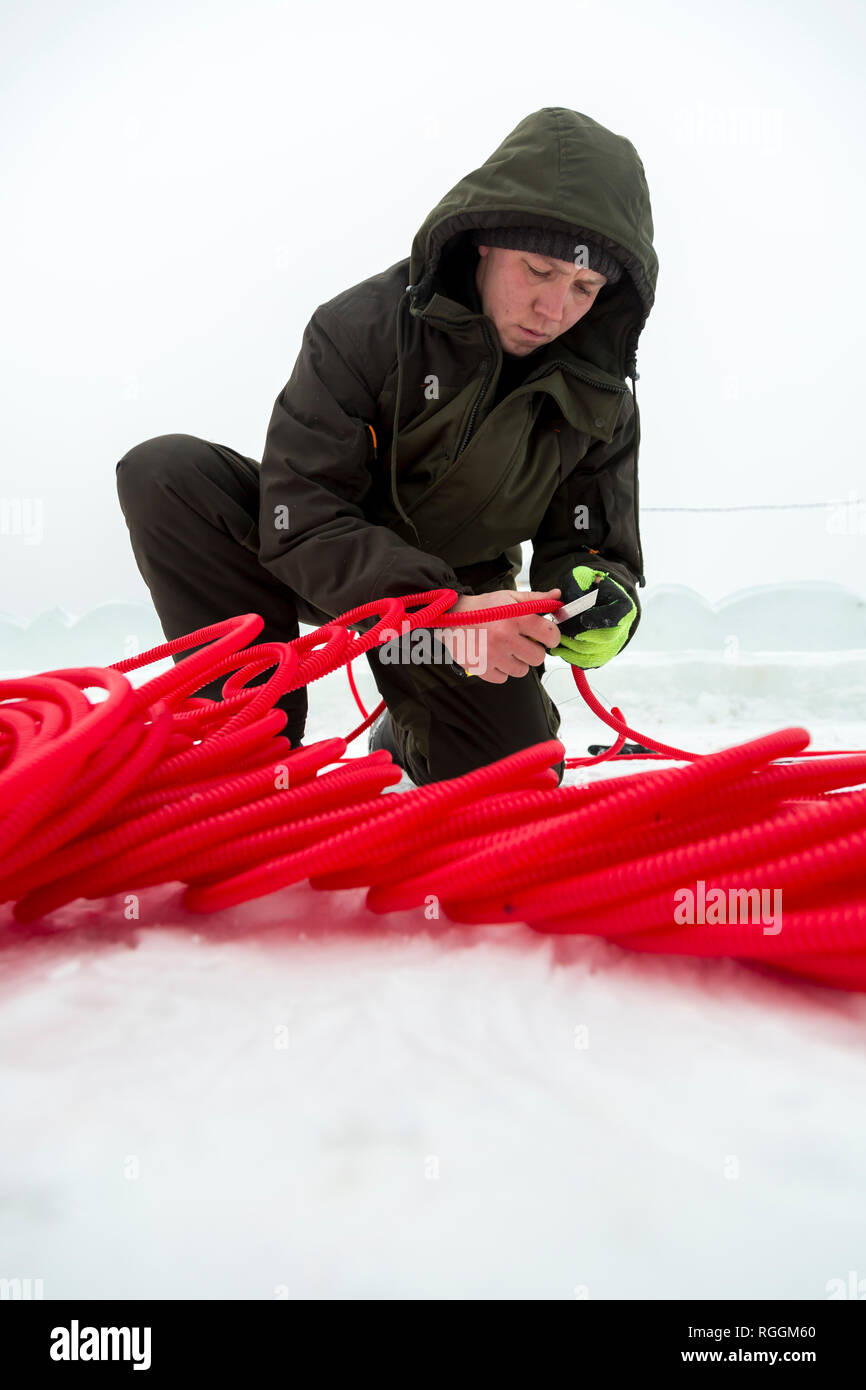 Electrician mounts power cable to illuminate ice figures Stock Photo ...