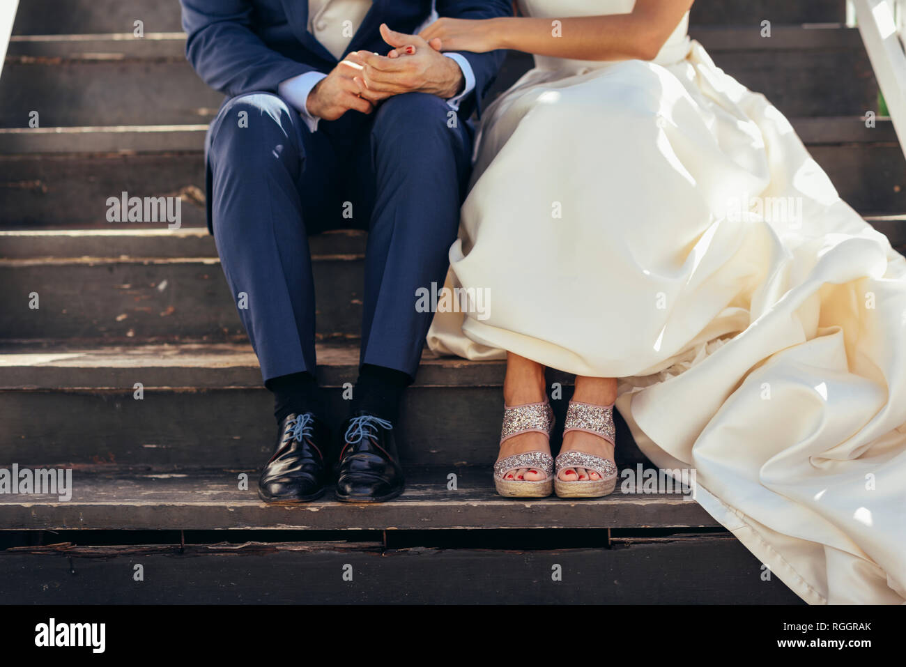 Bridal couple sitting on stairs outdoors, partial view Stock Photo - Alamy
