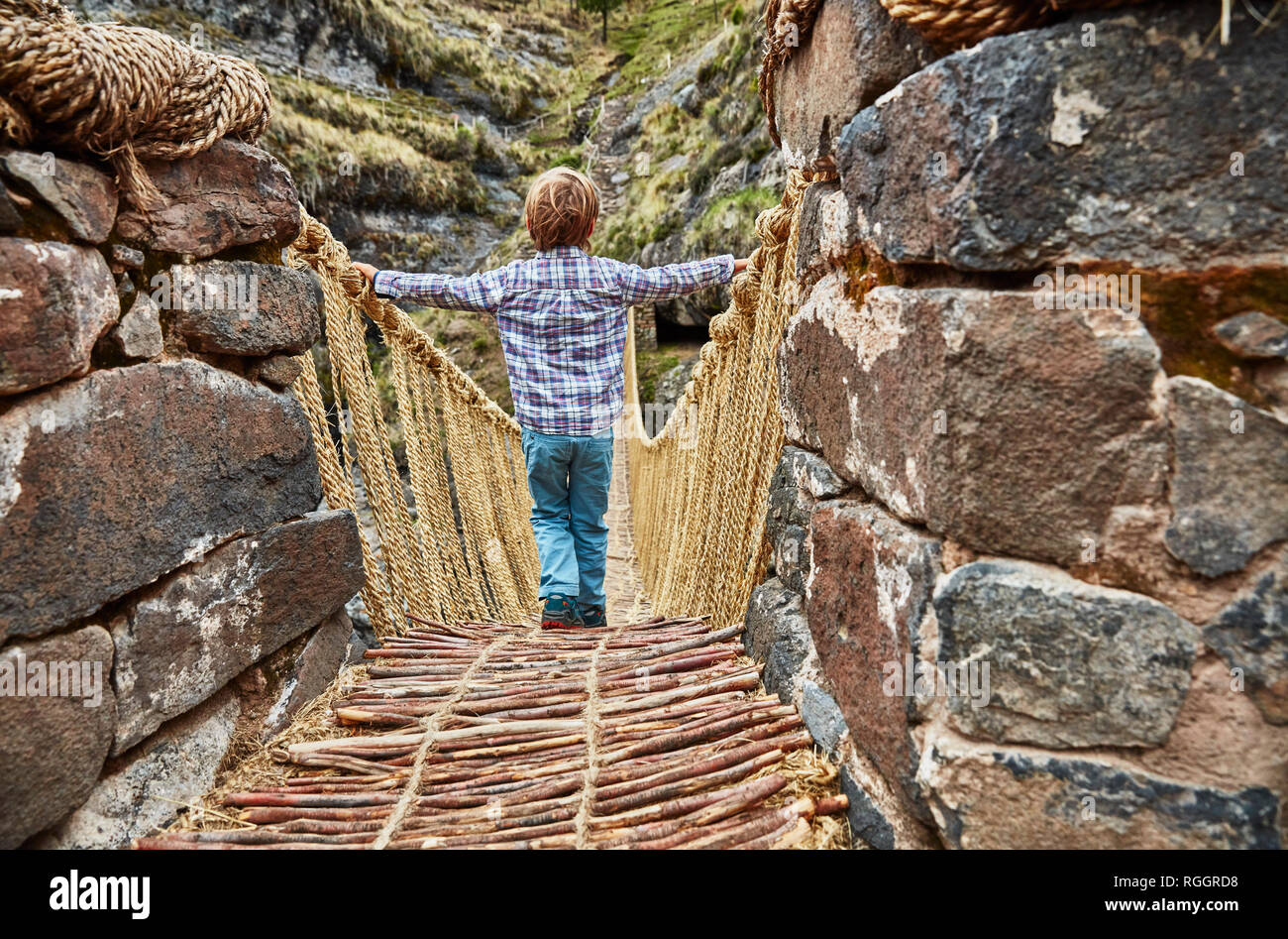 Peru, Quehue, boy crossing rope bridge Stock Photo - Alamy