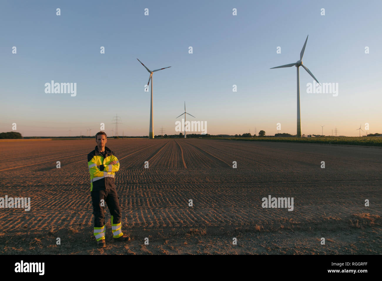 Engineer standing in a field at a wind farm Stock Photo - Alamy
