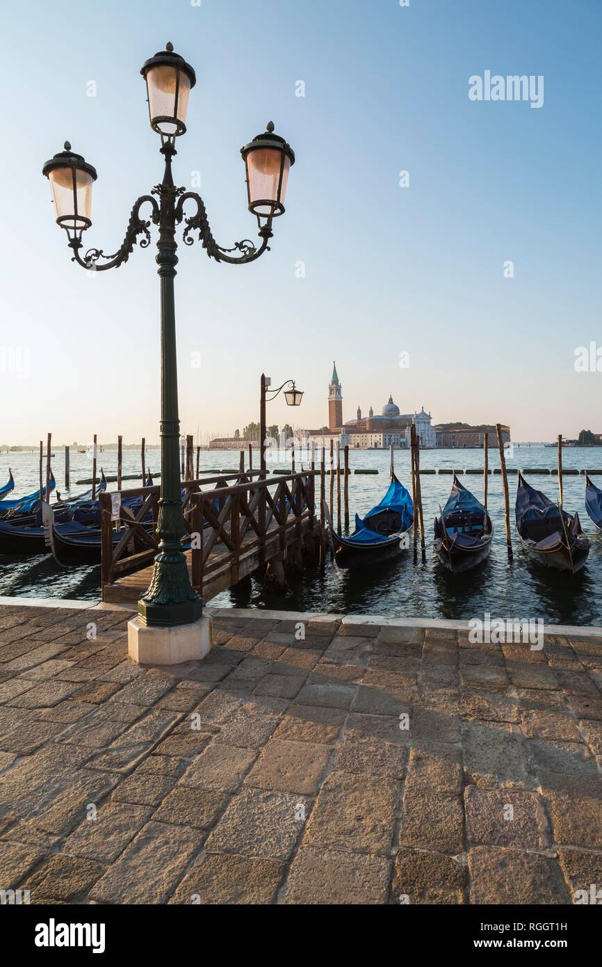 Lamppost with gondolas in San Marco and Benedictine church of San ...