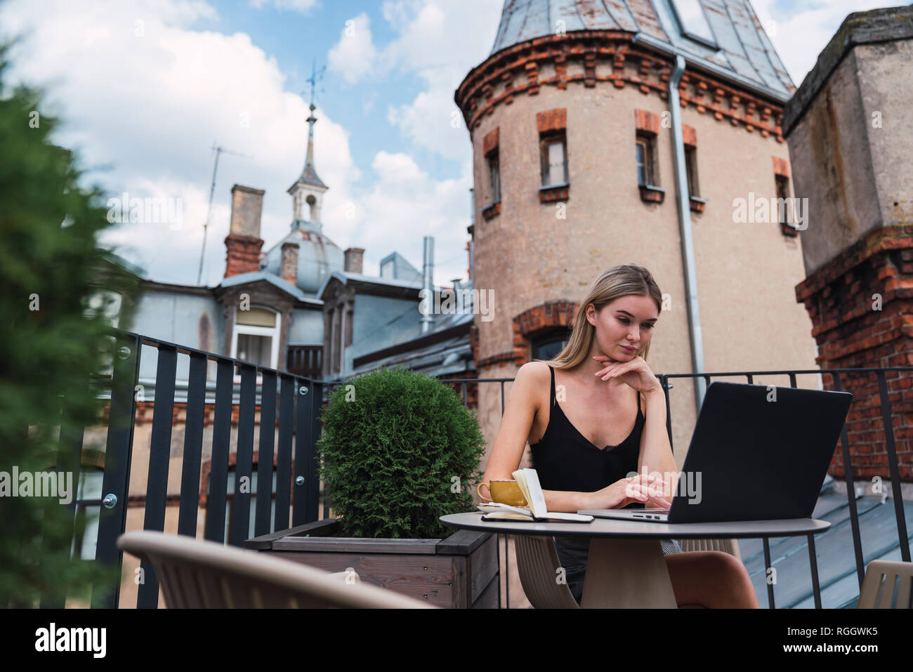 Young woman sitting on roof hi-res stock photography and images - Alamy