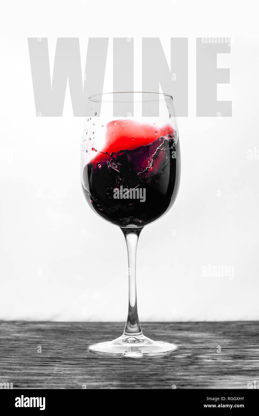 The red wine in the glass splashes in motion on a white background ...